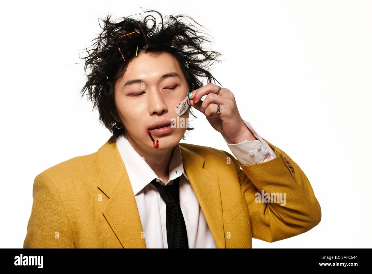 An asian man with blood on face posing in a yellow suit in a spring ...