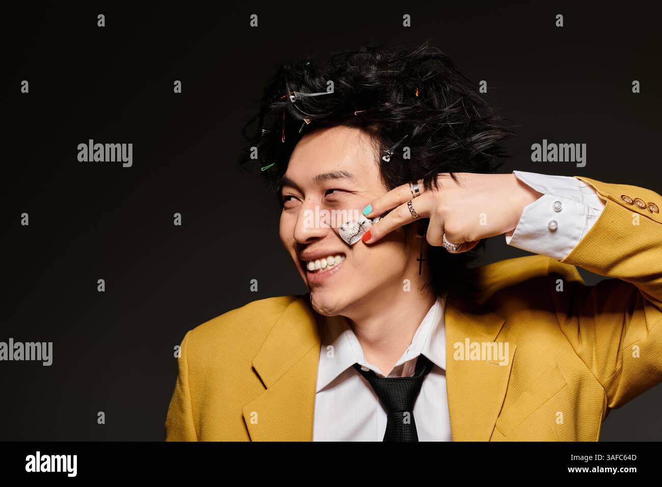 A fashionable Asian man with plaster on face showcases bold spring ...