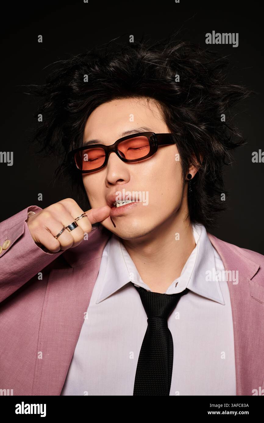 An asian man with blood on face displays trendy attire in a studio ...