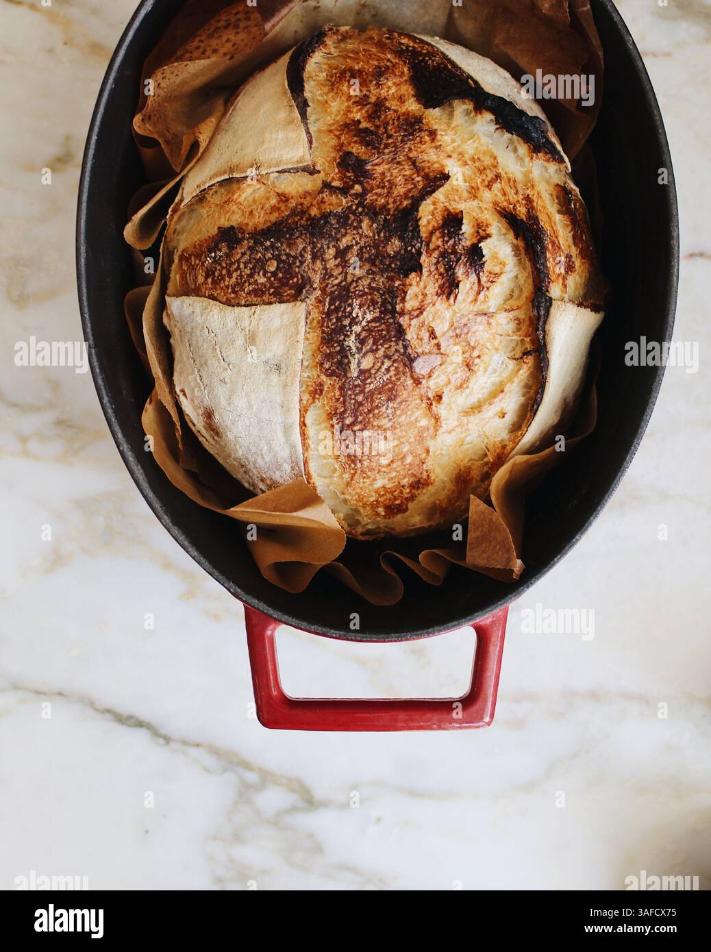 Classic freshly baked sourdough loaf bread on a marble kitchen counter ...
