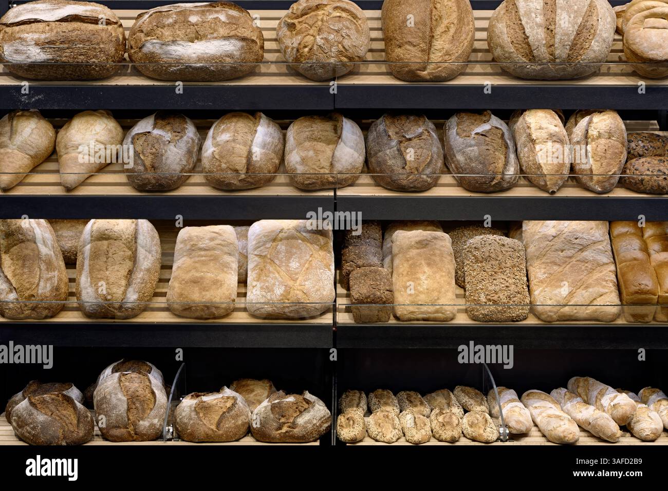 Various types of traditional homemade bread on the wooden shelves of a ...