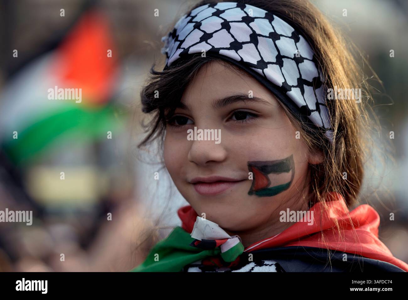 A girl with a Palestinian flag painted on her face attends a protest to ...