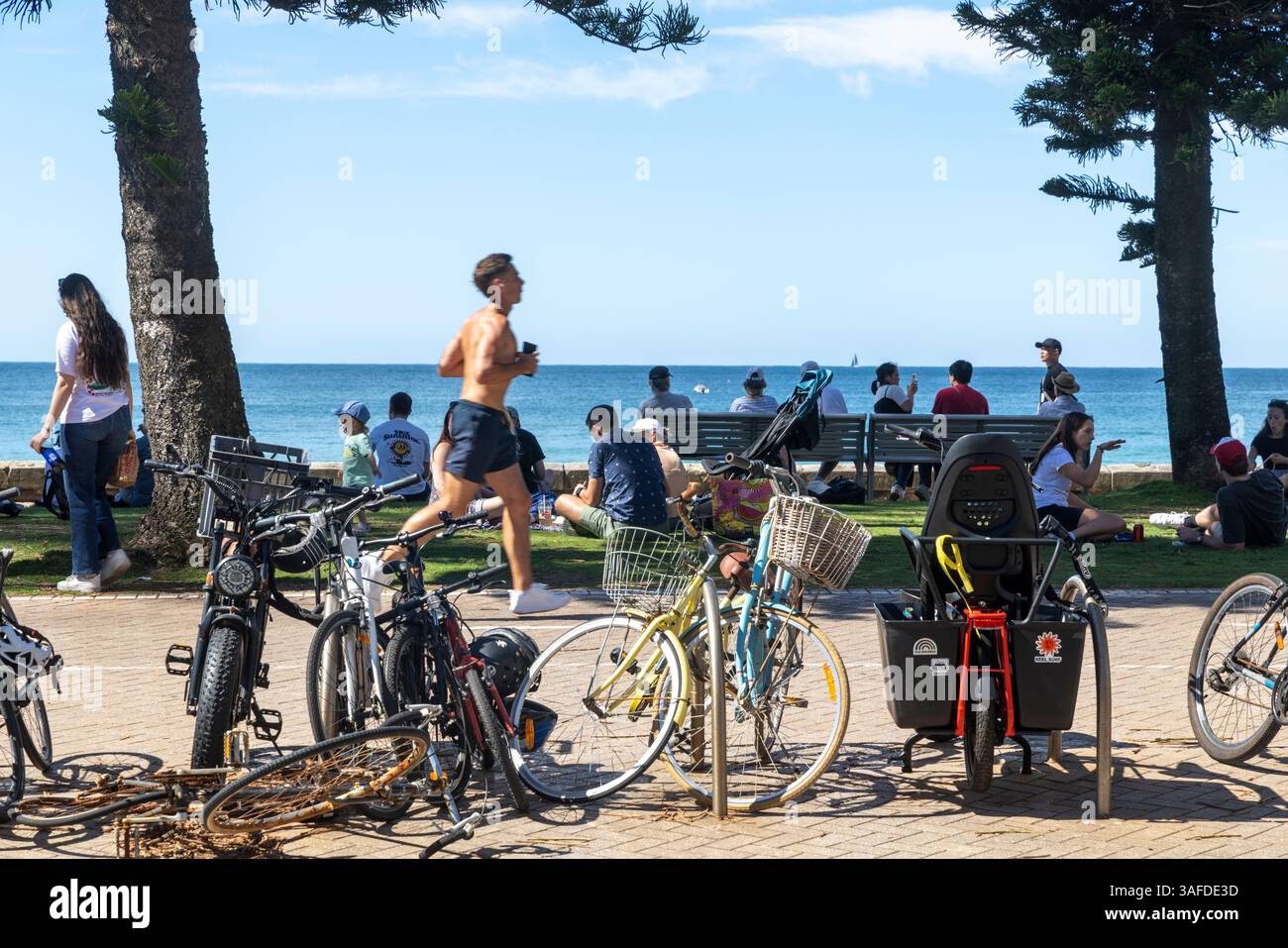 Beach lifestyle at Manly Beach in Sydney, man jogging past parked ...