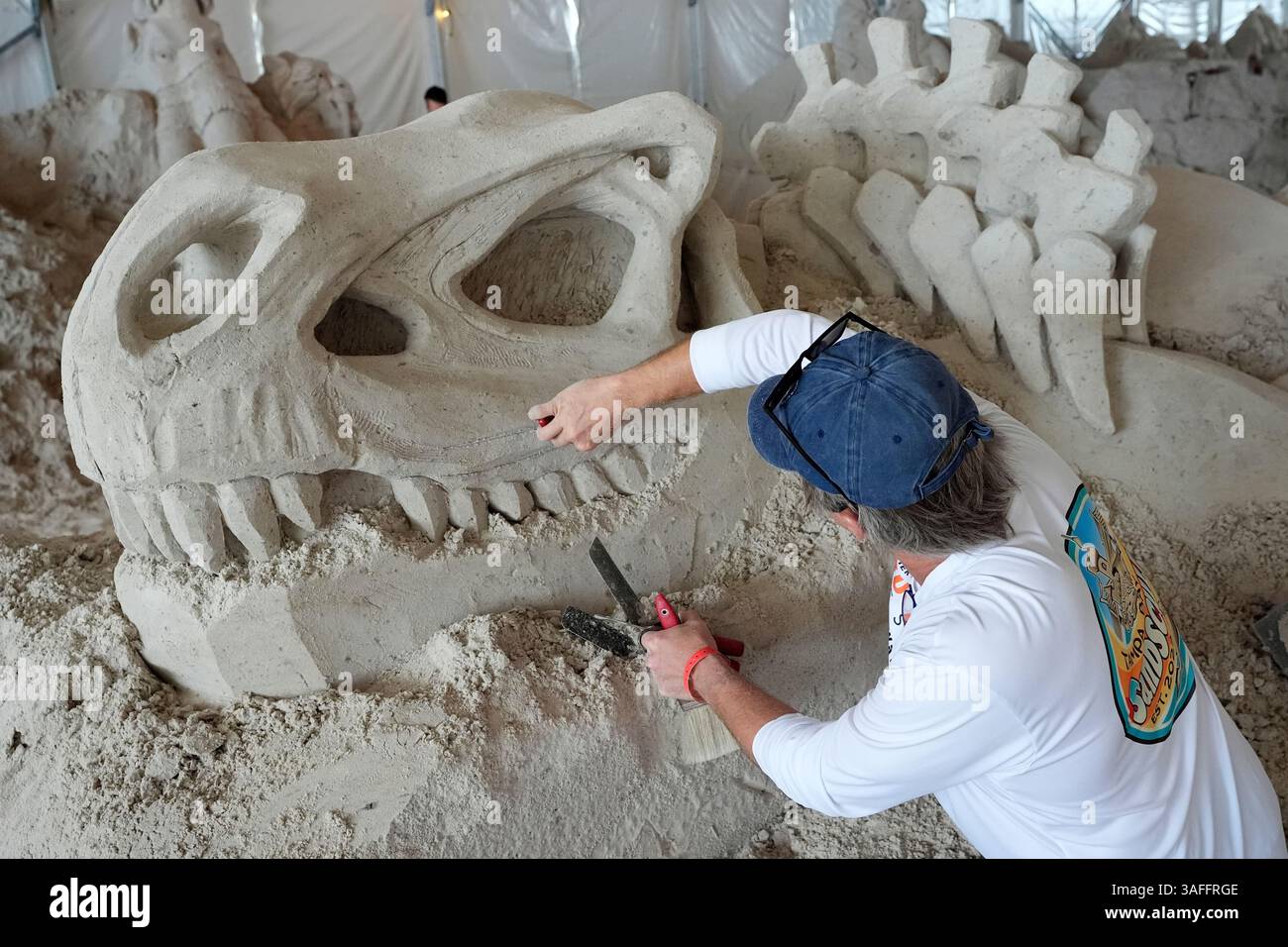 Dan Belcher, of St. Louis, Mo., works on his sand sculpture during ...