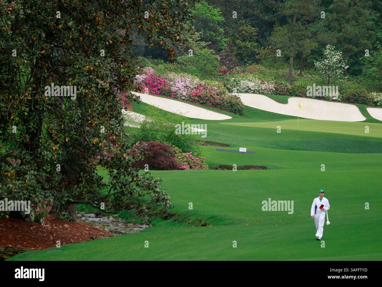 Chris Kirk's caddie Michael Cromie walks on the 13th fairway and tours ...