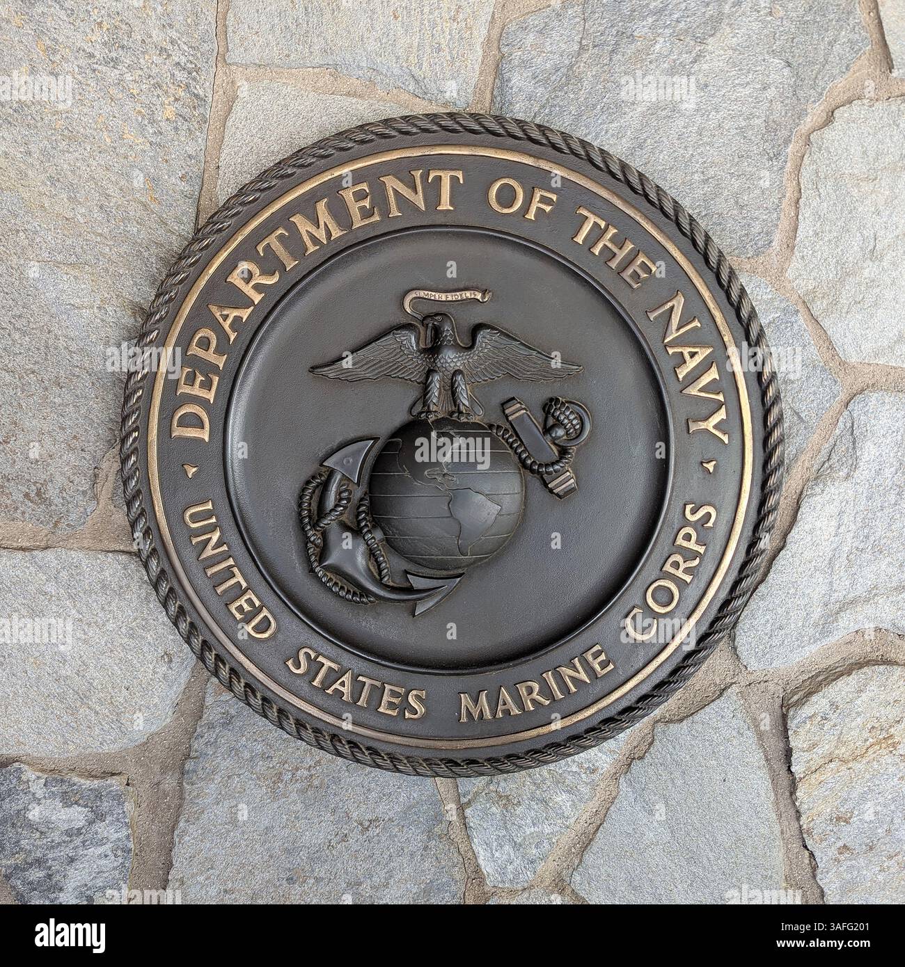 Bronze plaque of US Marine Corps emblem or crest on natural stone wall ...