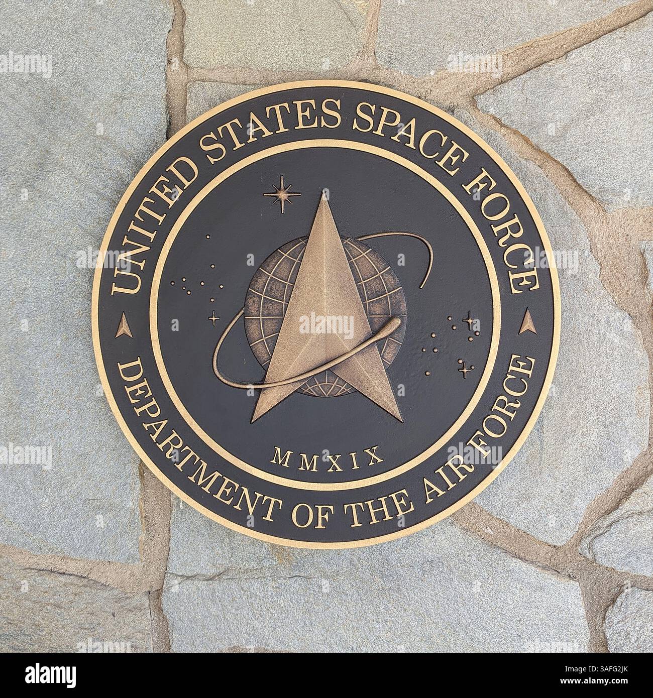 Bronze plaque of US Space Force emblem or crest on natural stone wall ...