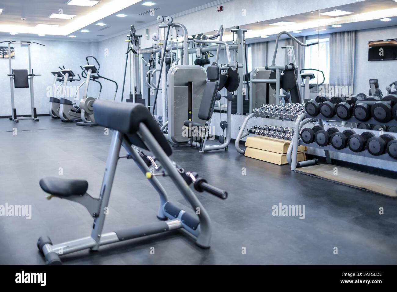 Modern fitness gym with professional workout equipment, dumbbells, and ...