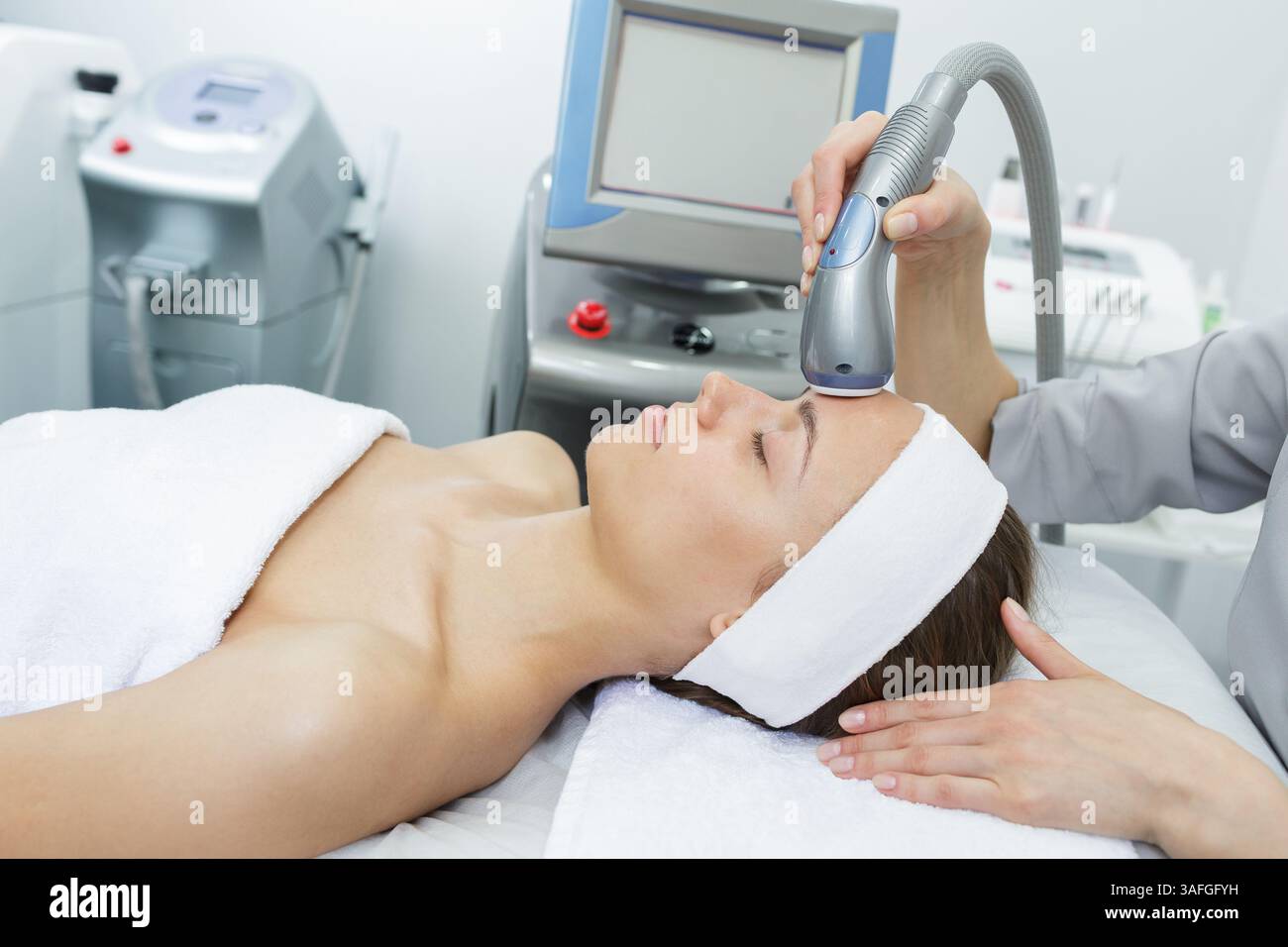 Cosmetologist performing a non-invasive facial rejuvenation treatment ...