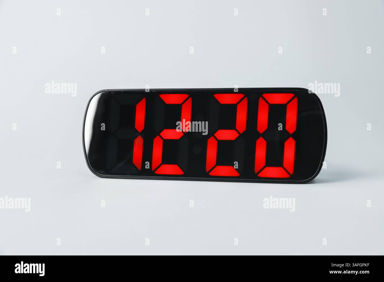 Digital alarm clock showing 12:20 o'clock on grey background Stock ...