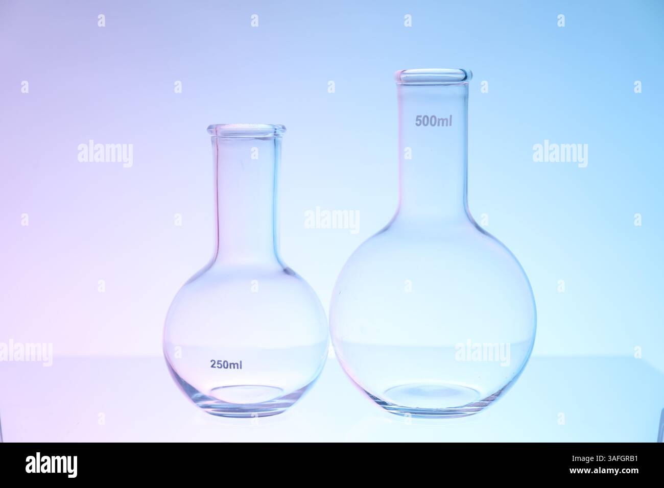 Empty flasks on color background. Laboratory glassware Stock Photo - Alamy