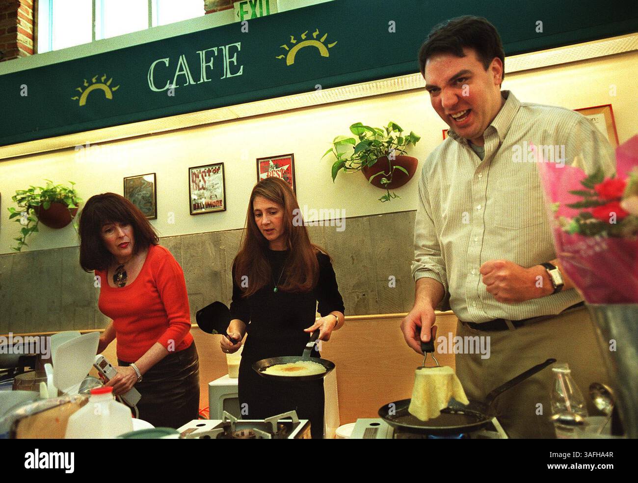 Jay Allen (right) reacts as he and Debra Mekos (center) make crepes ...