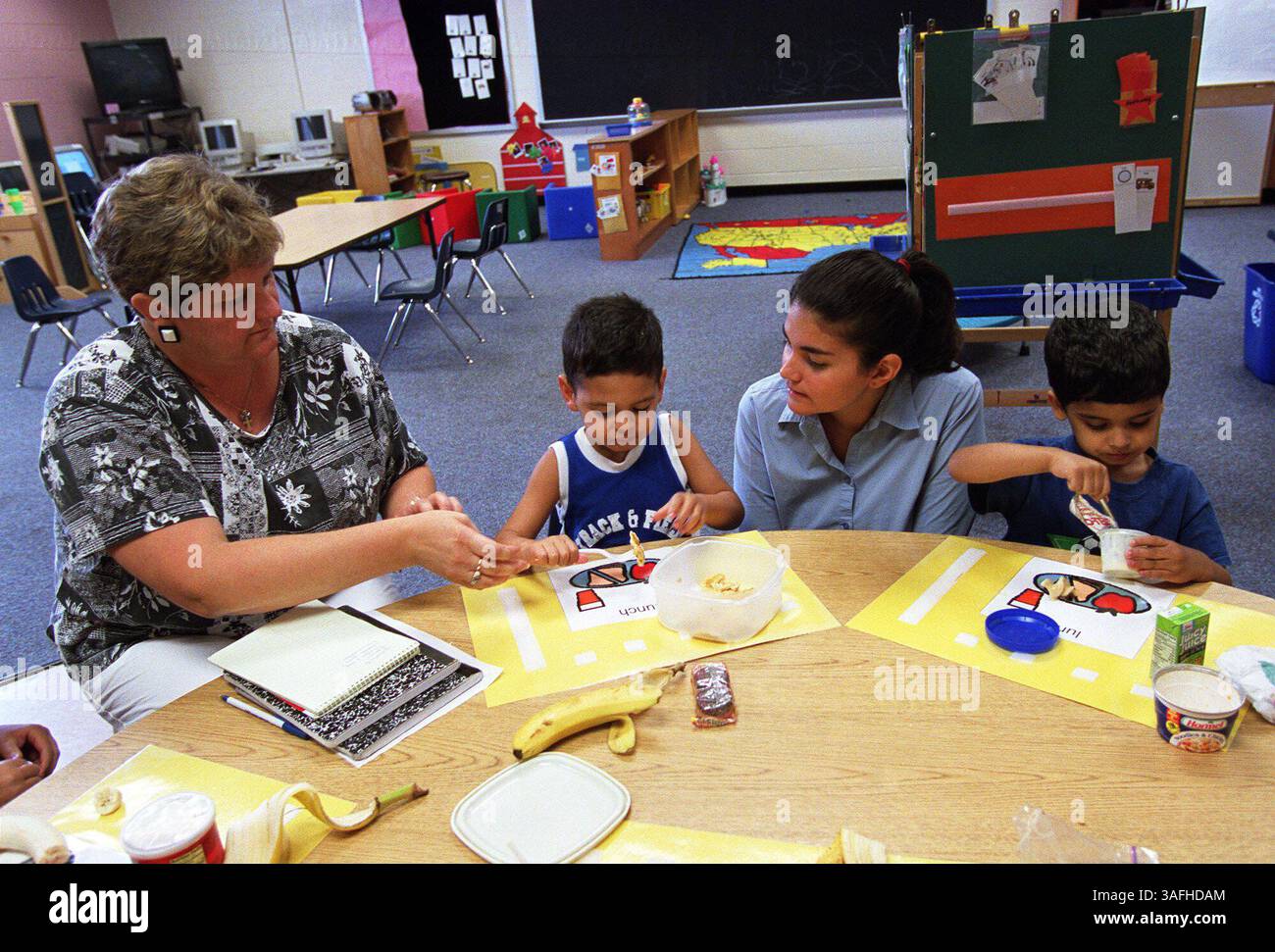 Elizabeth Panarelli sits on the floor between two boys during lunch in ...
