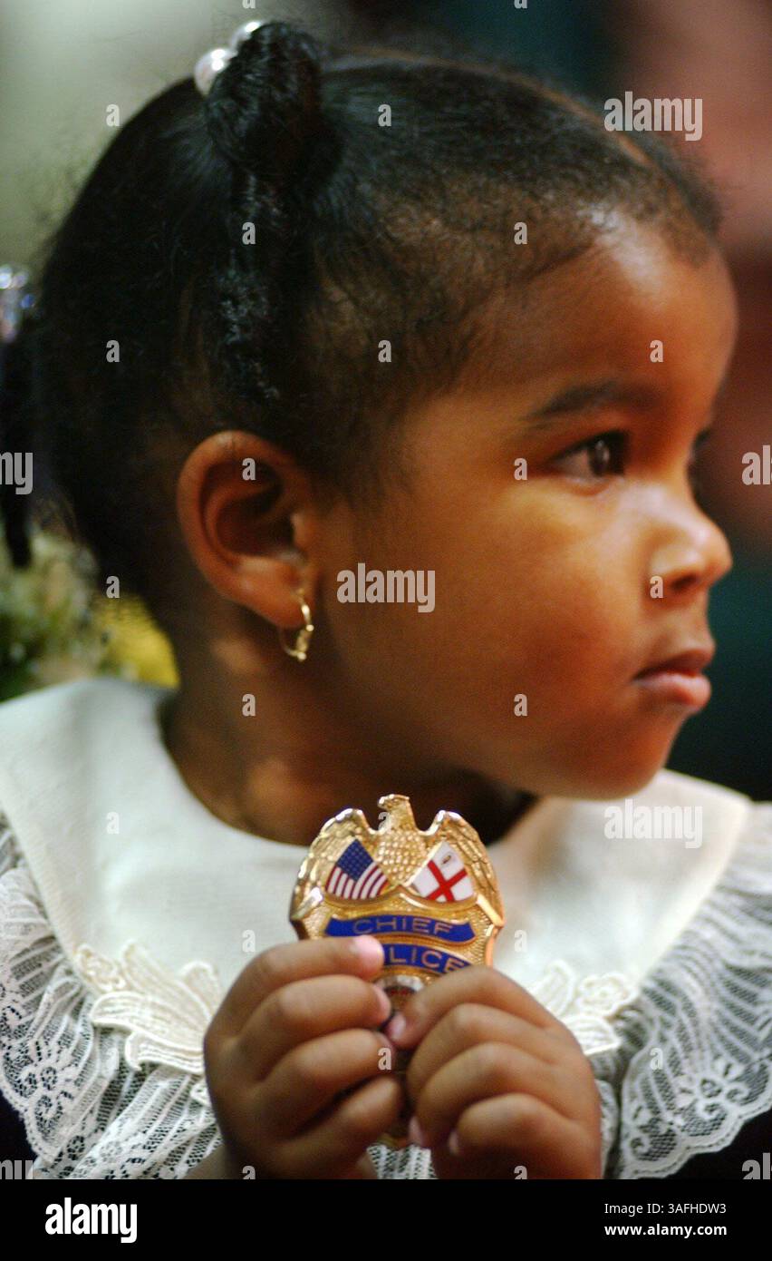 Taylor Wilson, 2, holds her father Gerald's badge before he is sworn in ...