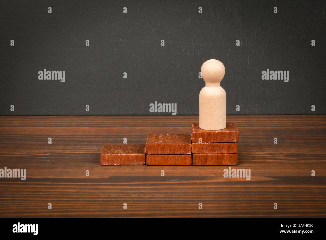 Wooden Figure on Stacked Blocks Representing Progress and Achievement ...