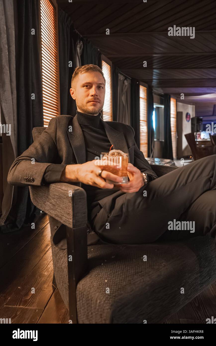 Man in Dark Suit Relaxing in Elegant Lounge with Warm Lighting Stock ...
