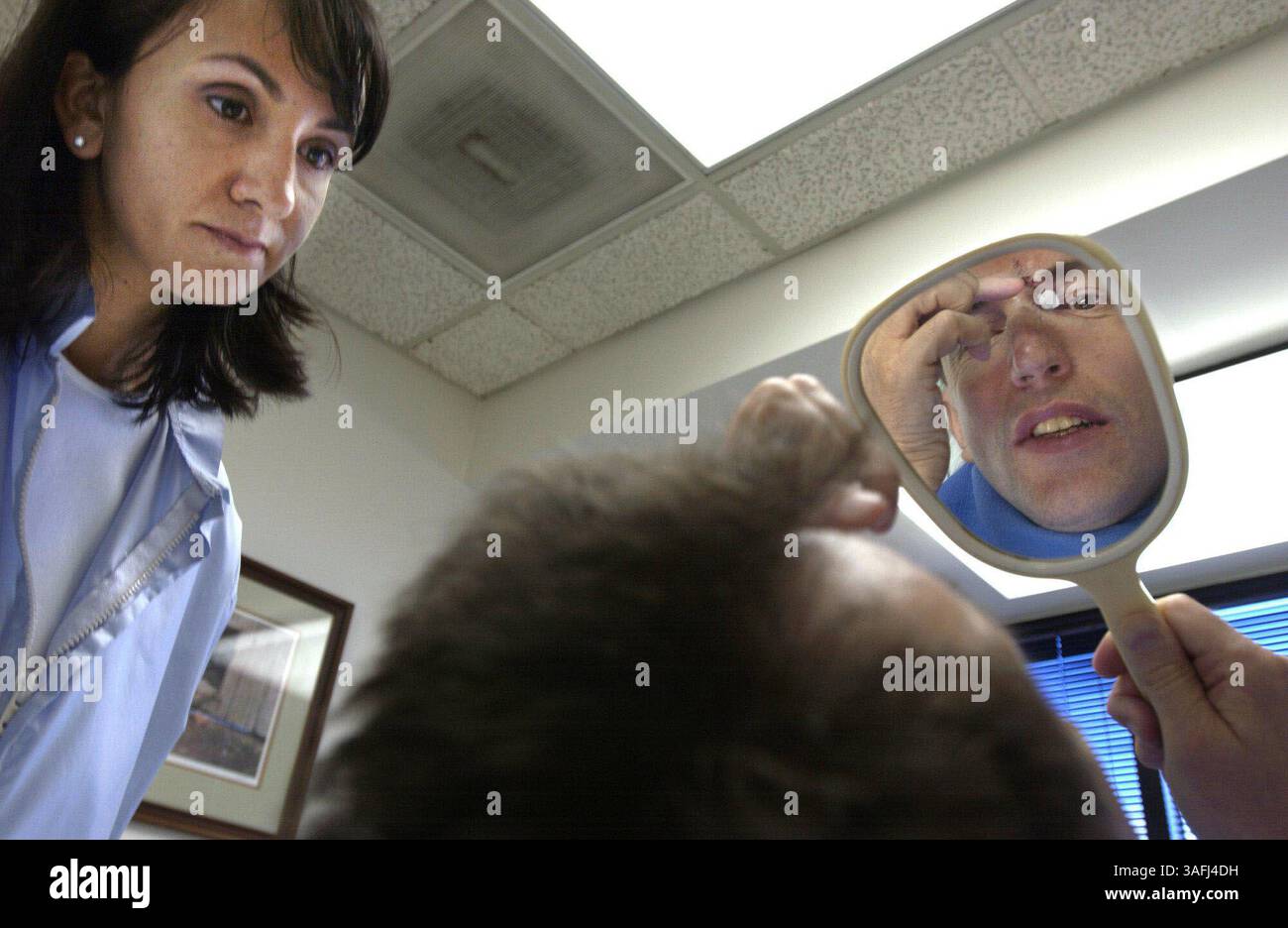 Yury Kutchinsky looks at the bandaging technique for his wound site as ...