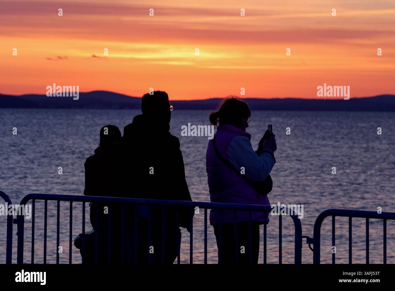 People enjoy the beautiful sunset at the Greeting to the Sun. Monument ...