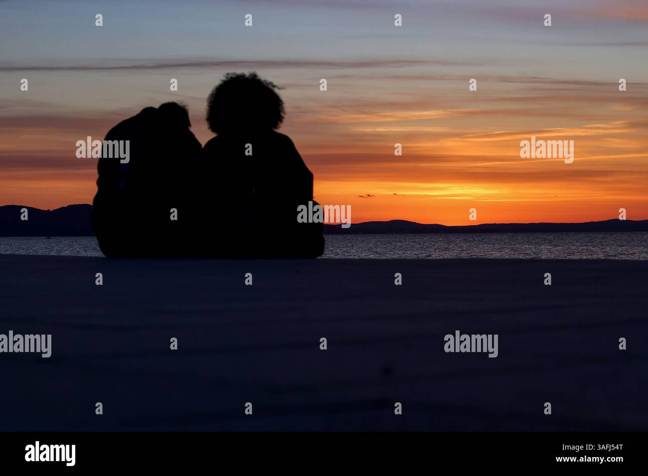 People enjoy the beautiful sunset at the Greeting to the Sun. Monument ...