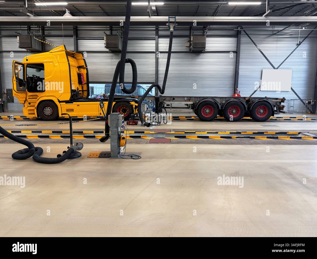 Yellow truck undergoing procedure of vehicle inspection at station ...