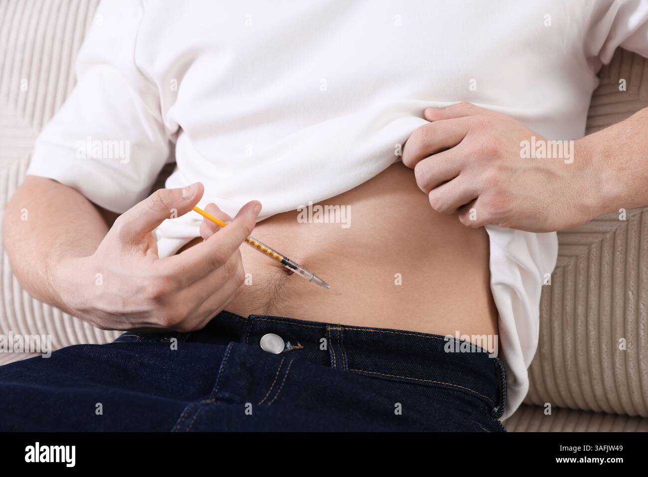 Man making insulin injection into his belly indoors, closeup. Diabetes ...
