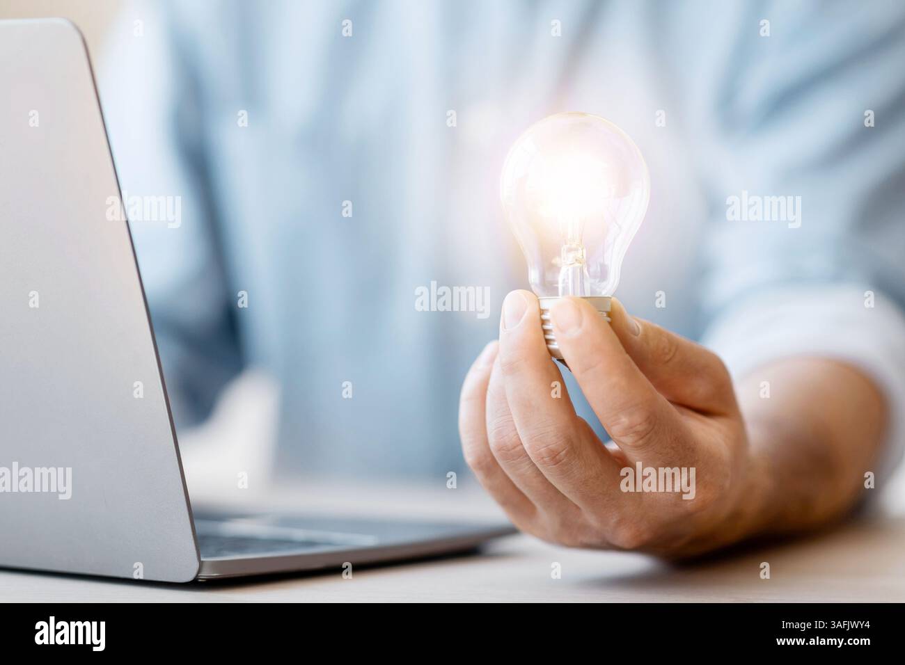 Idea Concept. Unrecognizable businessman holding illuminated light bulb ...