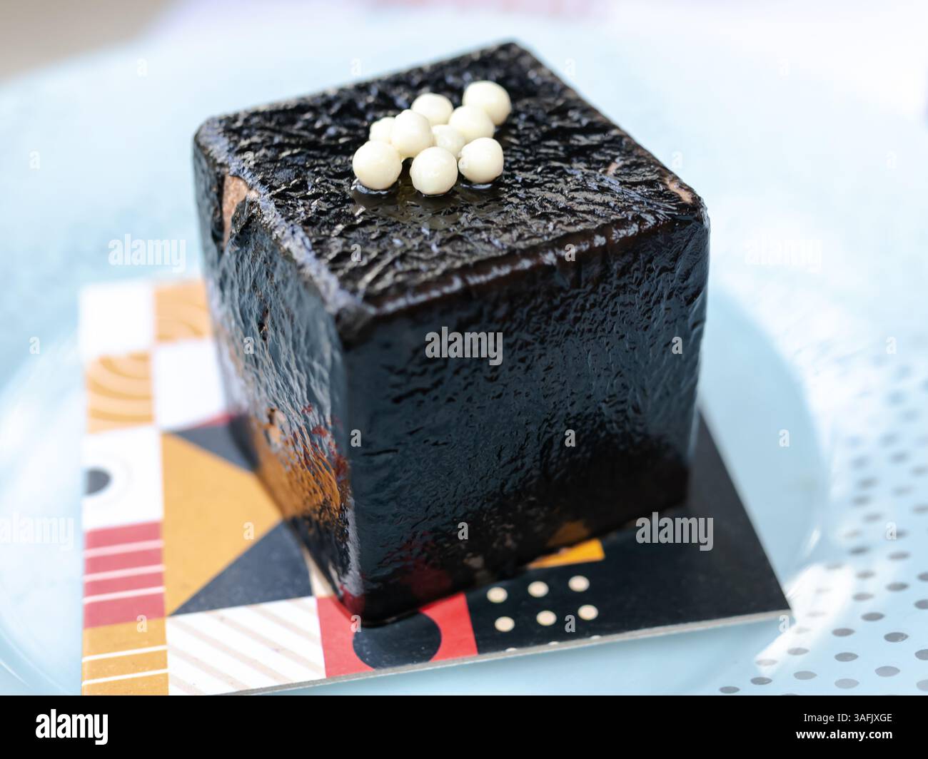 Elegant Dark Chocolate Cube Dessert with White Pearls Stock Photo - Alamy