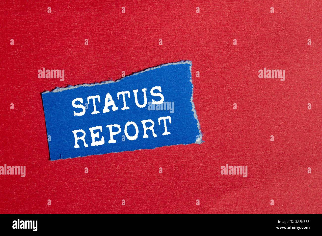 Status report message written on ripped torn blue paper piece on red ...
