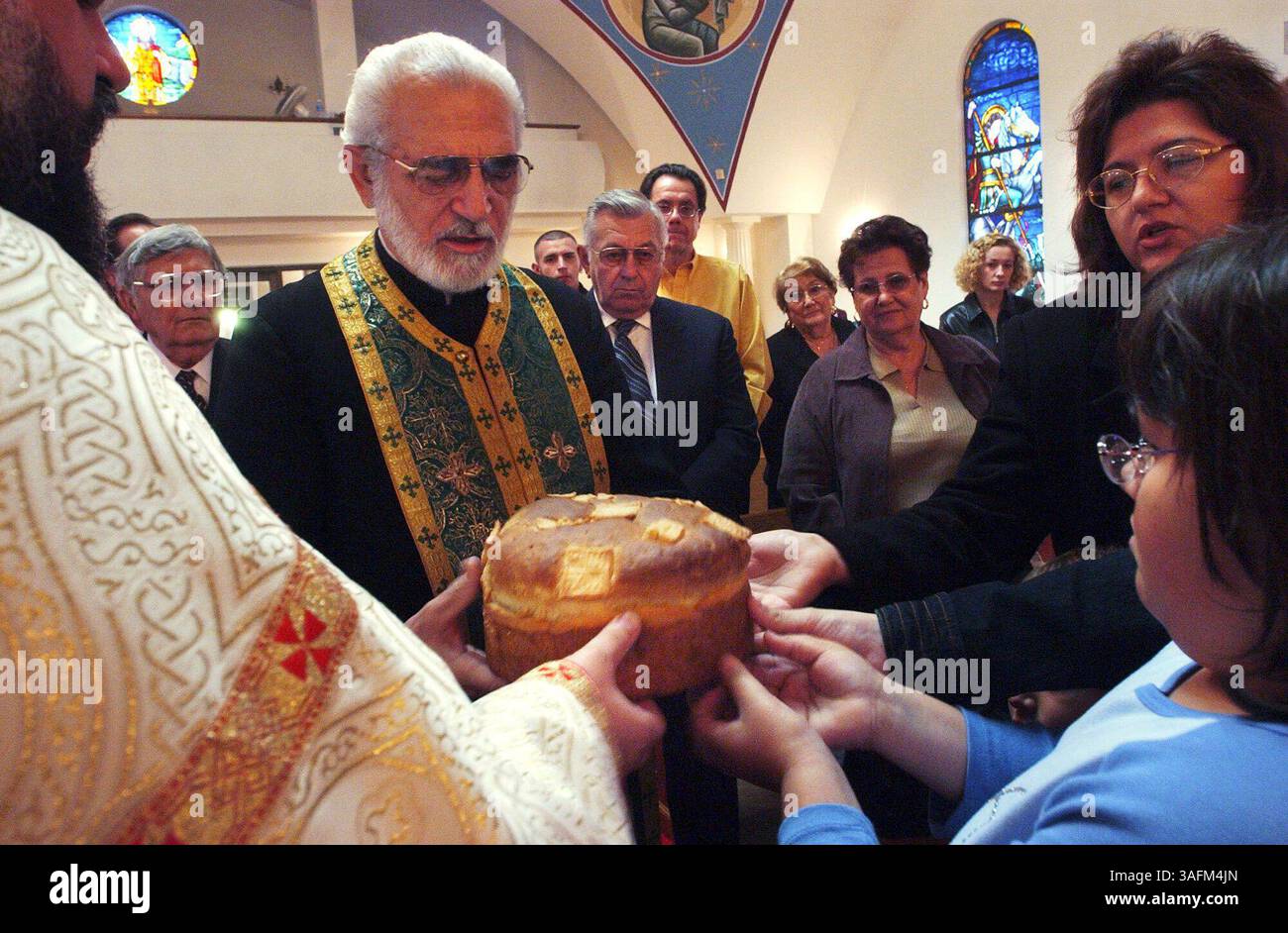 Father Miloje turns the crown shaped bread symbolizing Jesus Christ ...