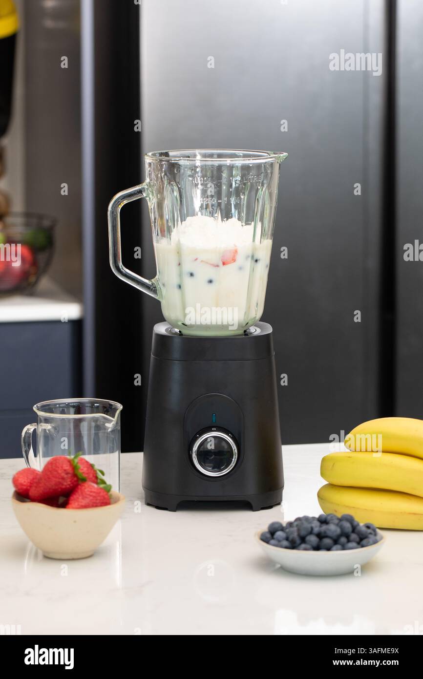 Making a fresh berry smoothie in modern kitchen setting for healthy ...