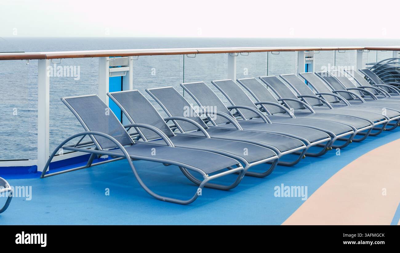 A serene view of blue deck chairs perfectly arranged in neat rows on a ...