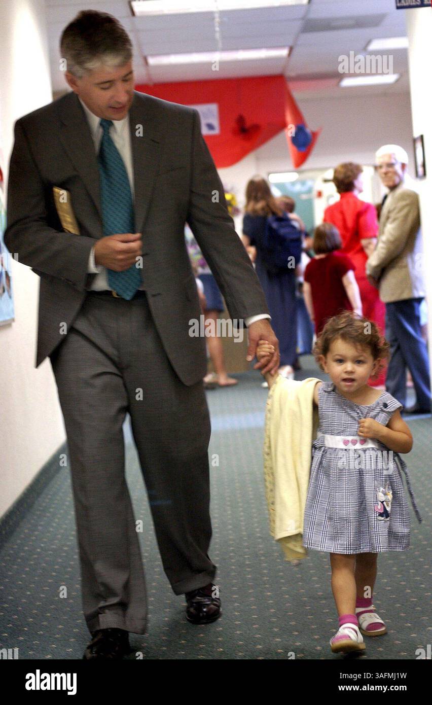 Photo 3 of 3. Pastor Ed Kuffel leads his daughter Katy, 2, down the ...