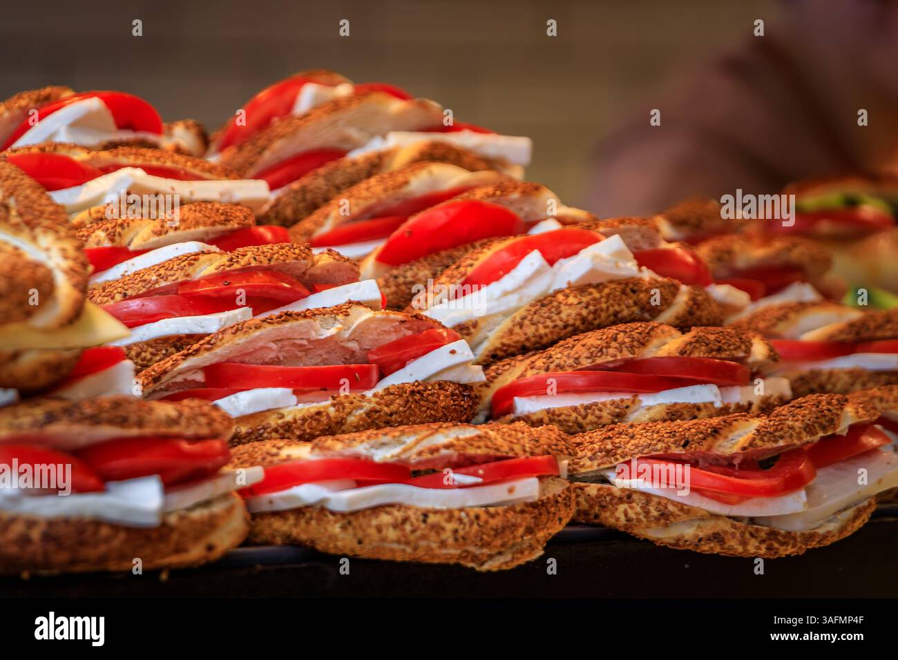 Stacked traditional simit sandwiches with cheese and tomato prepared ...