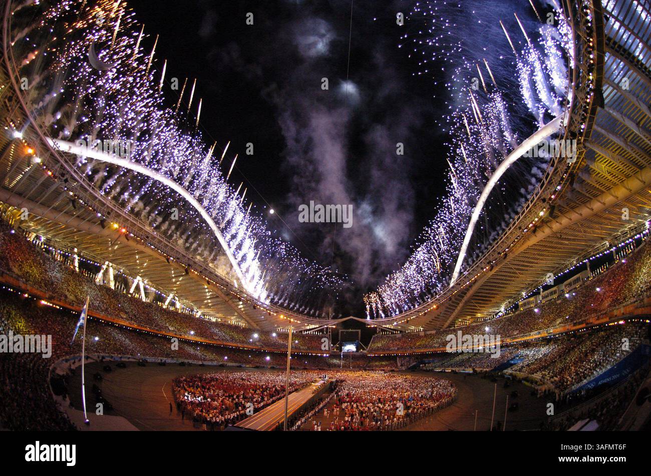 The athletes of the world encircle the main stage as fireworks light up ...