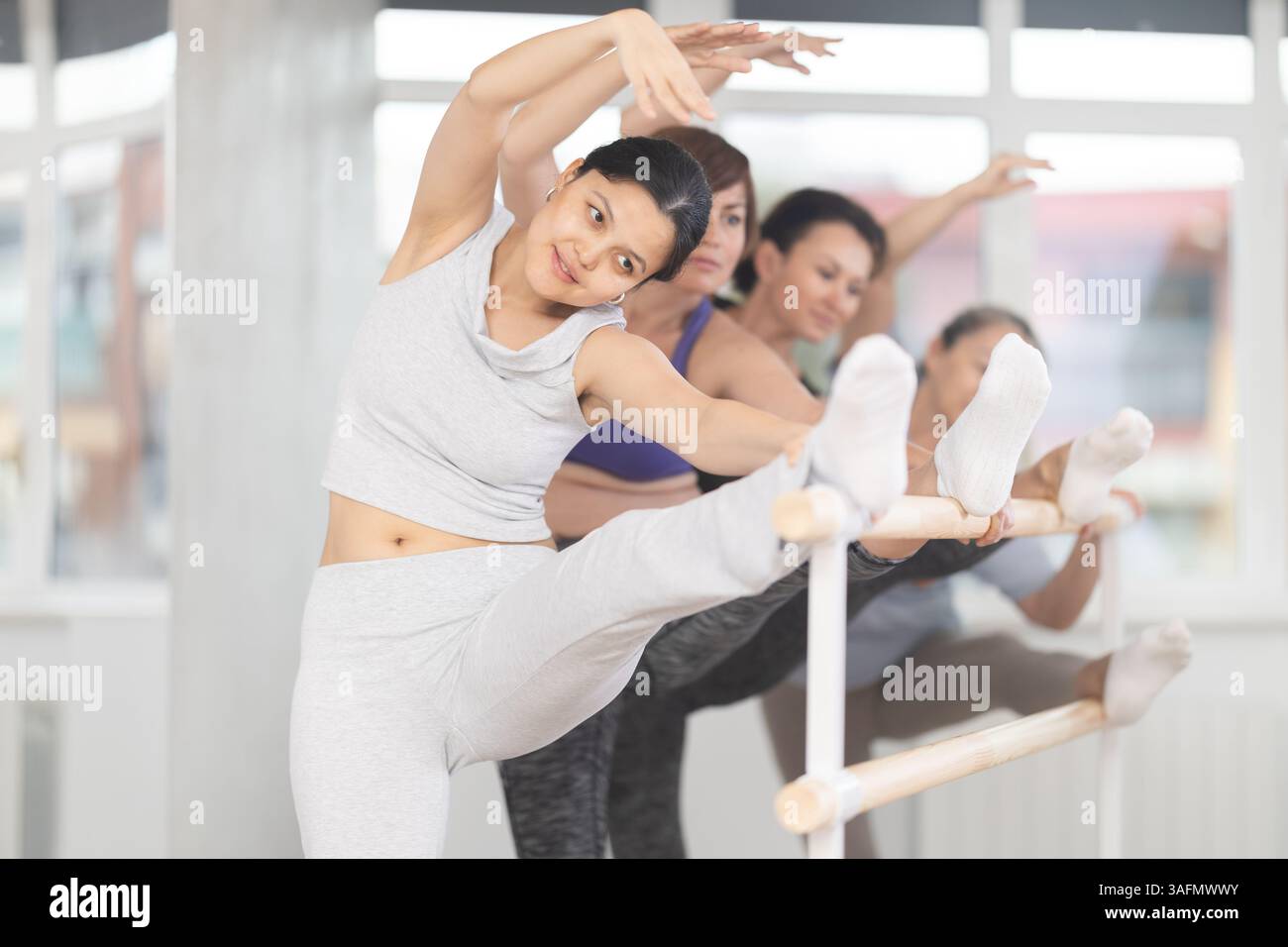 Group of women stretching at ballet barre Stock Photo - Alamy
