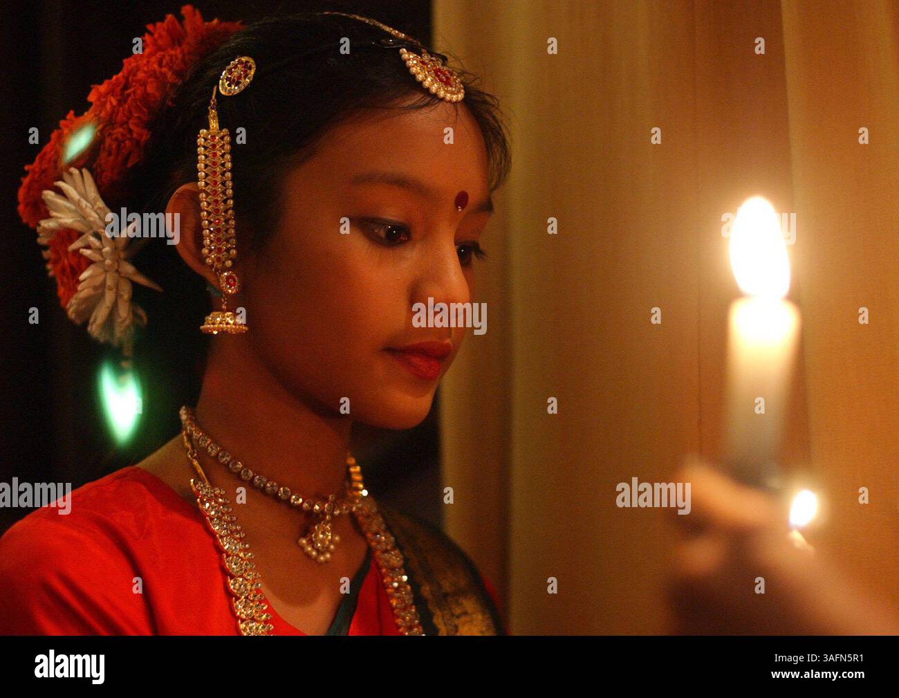 Caption: Radha Nath (cq) is handed a candle as she enters the India ...