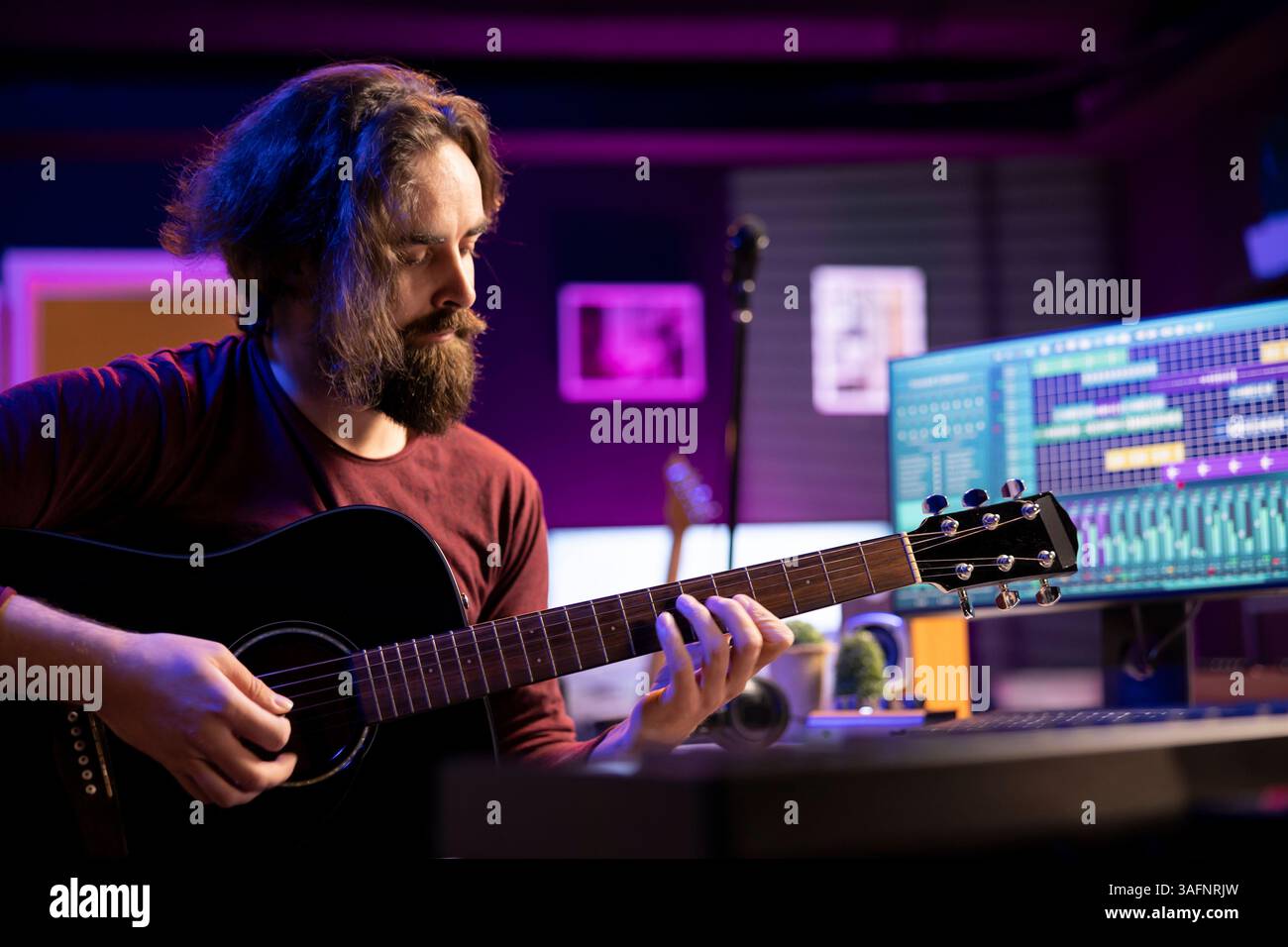 Skilled musician playing acoustic guitar and recording new tunes to use ...