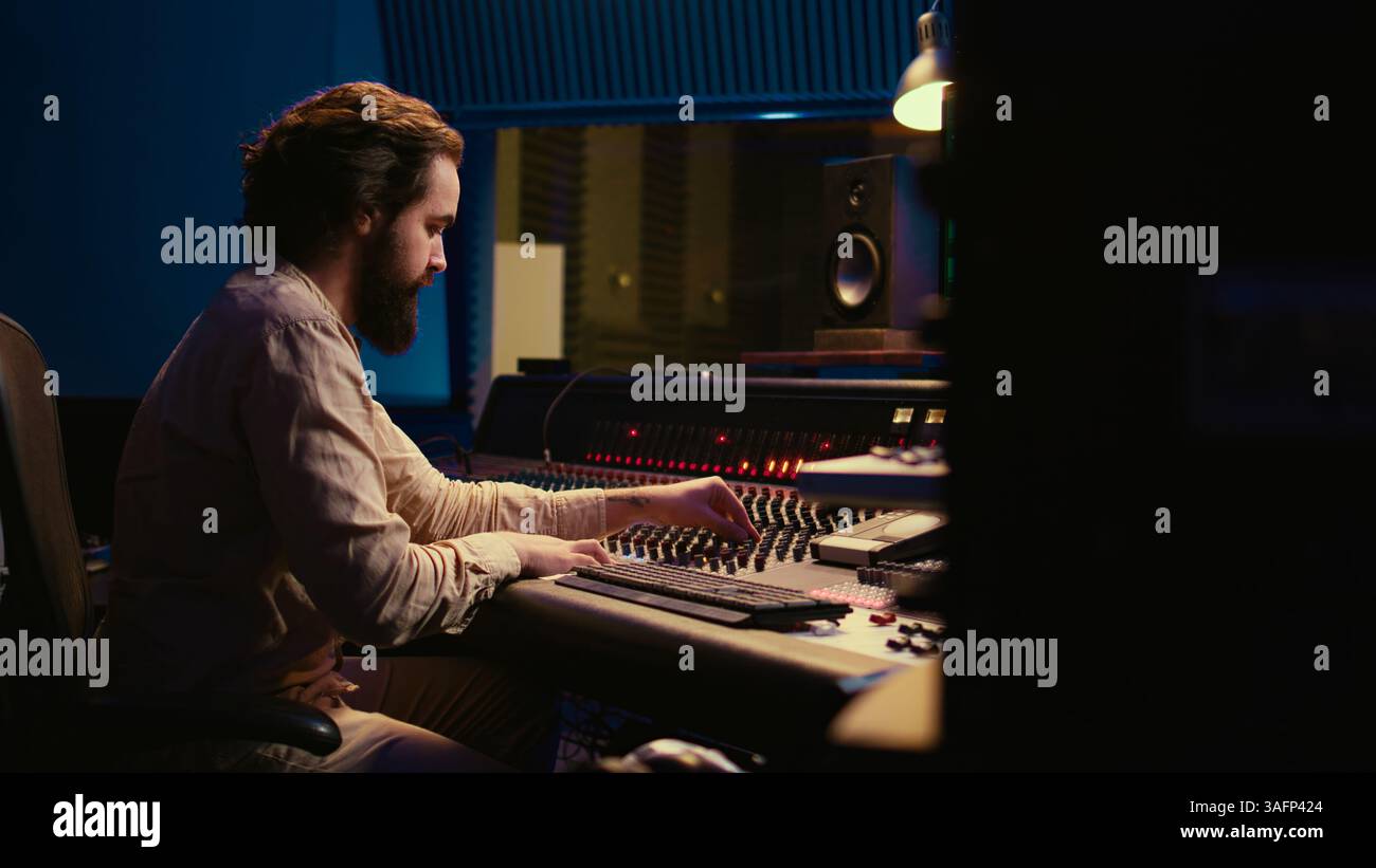 Portrait of sound engineer recording audio and editing with mixing ...