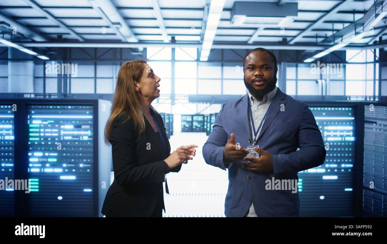 Teamworking colleagues looking at holograms in data center, working together. Server hub IT ...