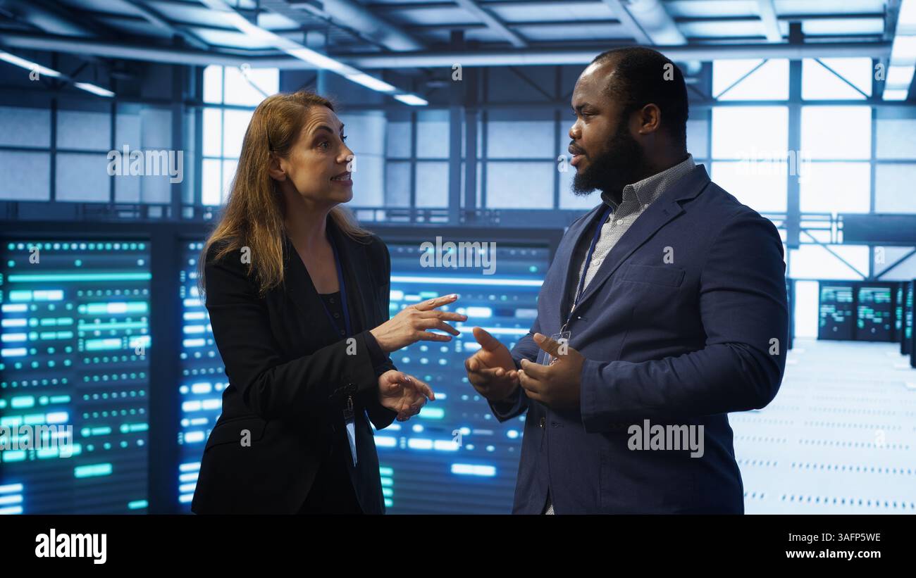 Teamworking colleagues looking at holograms in data center, working together. Server hub IT ...