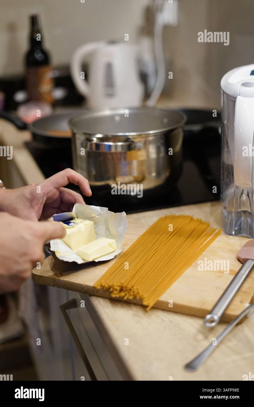 Man husband cook cut butter italian pasta wooden desk home cuisine ...