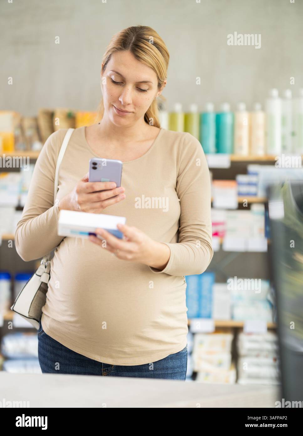 Pregnant woman customer scanning QR-code on ointment box Stock Photo ...