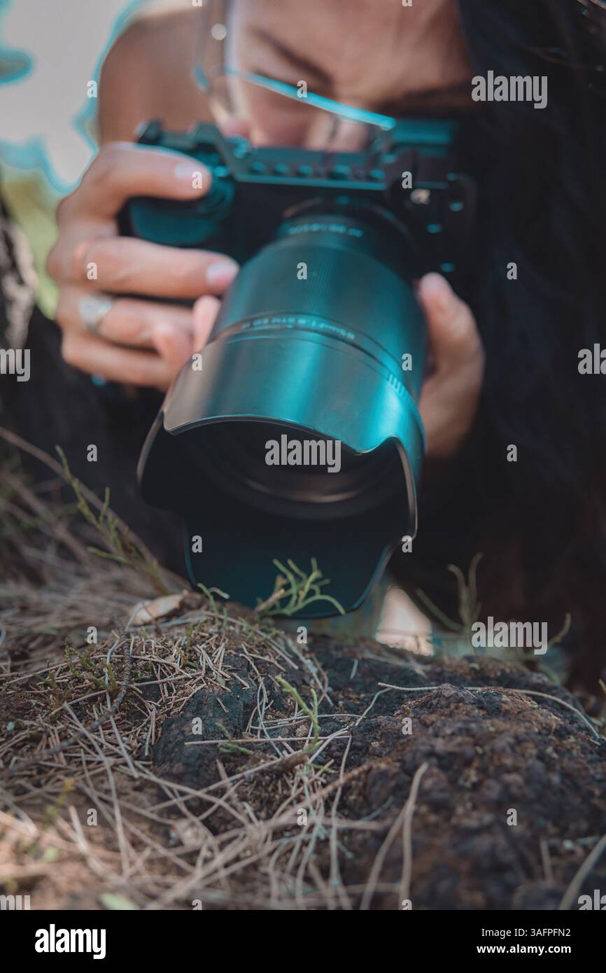Woman photographer holding a professional camera, is taking a picture ...