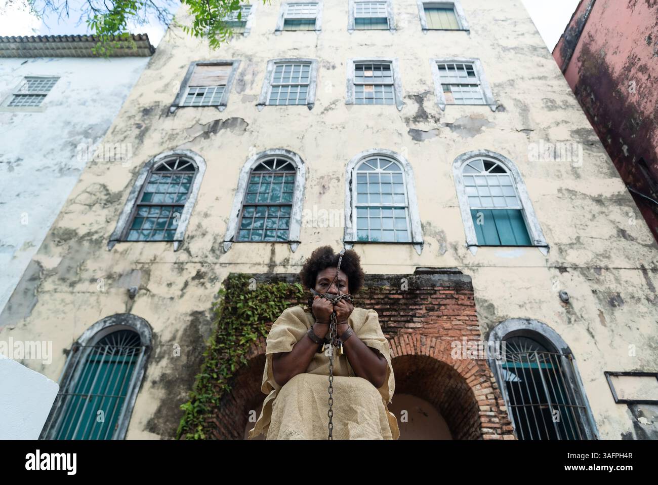 Black woman dressed as a slave, chained and with an iron mask on her ...