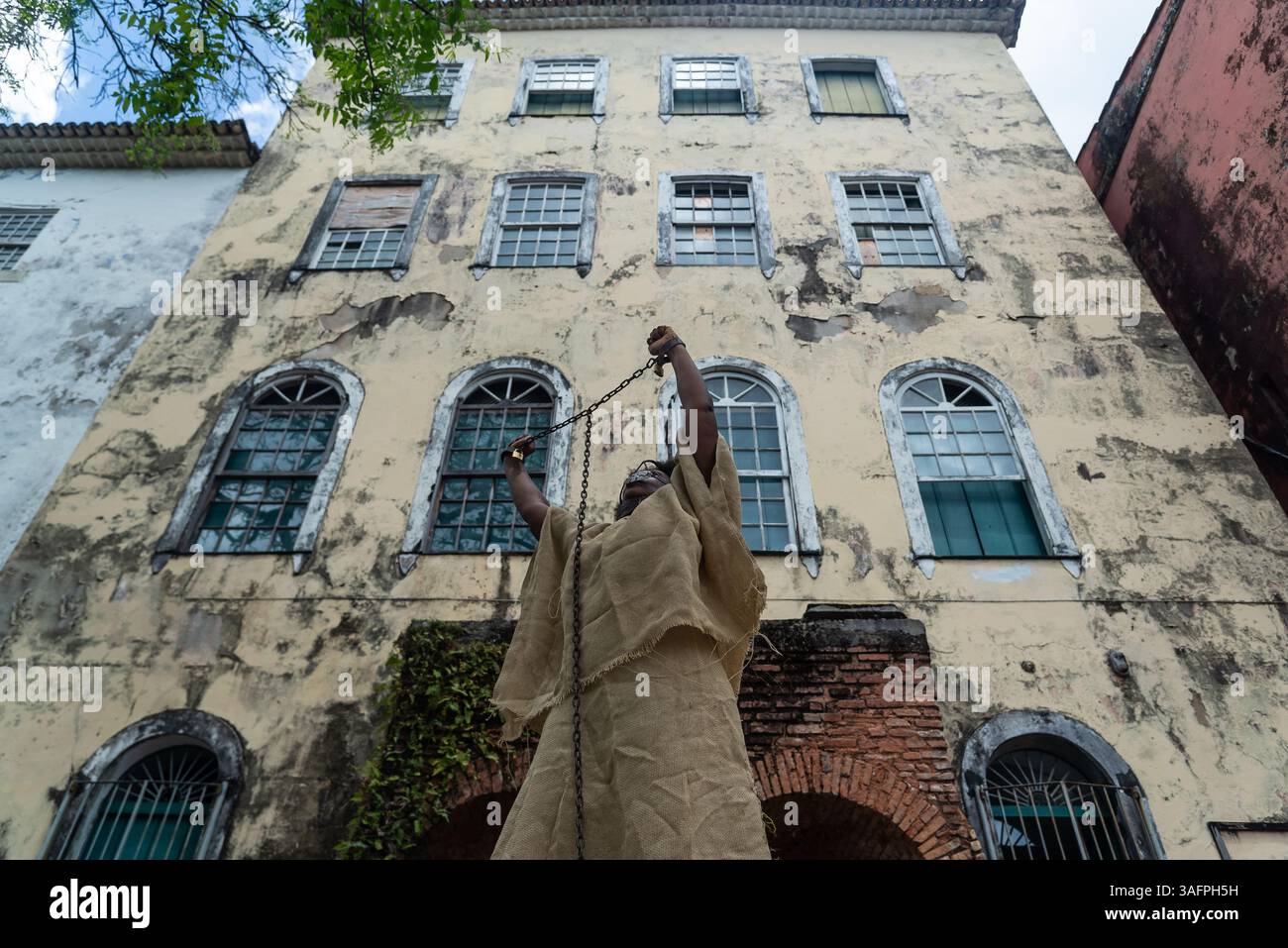 Black woman dressed as a slave, chained and with an iron mask over her ...