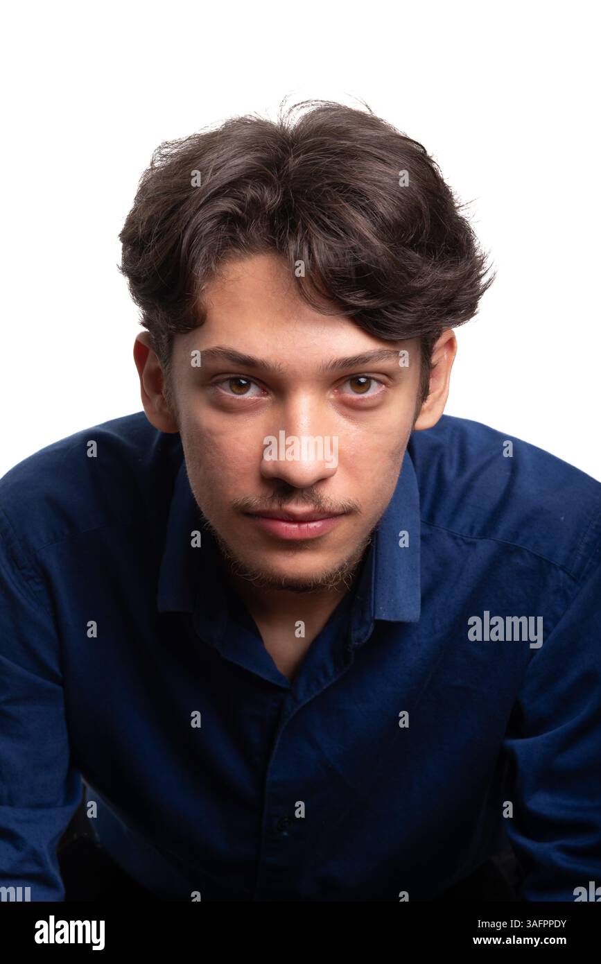 Close-up portrait of handsome young man with black hair and blue shirt ...