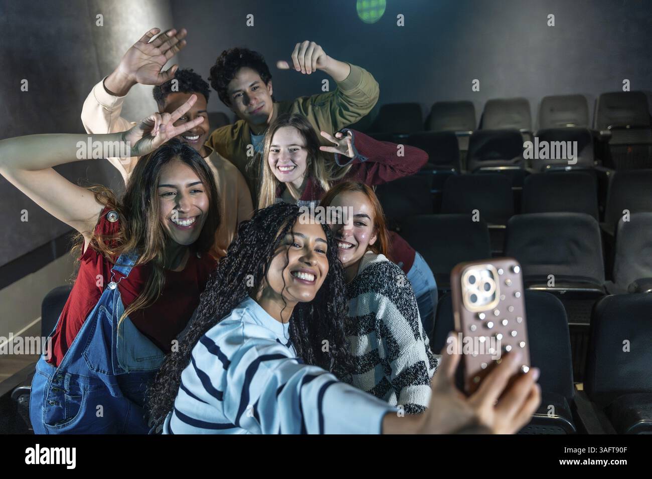 Group of smiling friends taking a selfie at the cinema, enjoying a ...