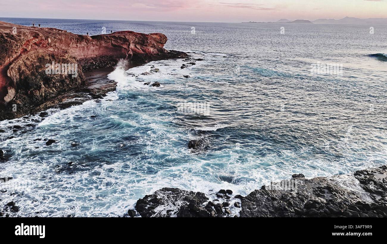 Breathtaking coastal landscape with waves hitting the cliffs at sunset ...