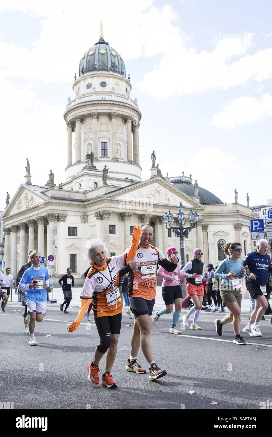 Two runners in front of the German Cathedral at Gendarmenmarkt at the ...