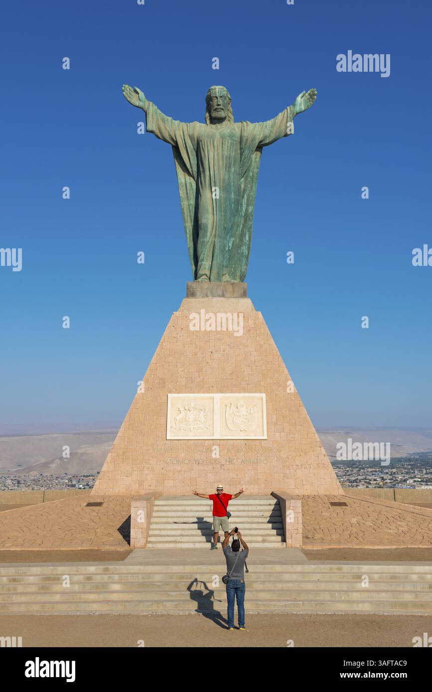 Tourists taking photos in front of the large statue of Christ on the ...